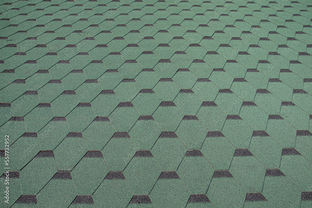 Roofing made of green soft bitumen tiles on a hipped roof of a house ...