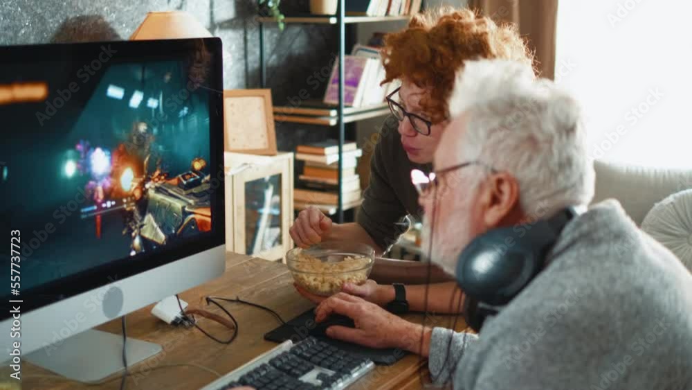 A cheerful old man spends time playing a professional mock-up video ...