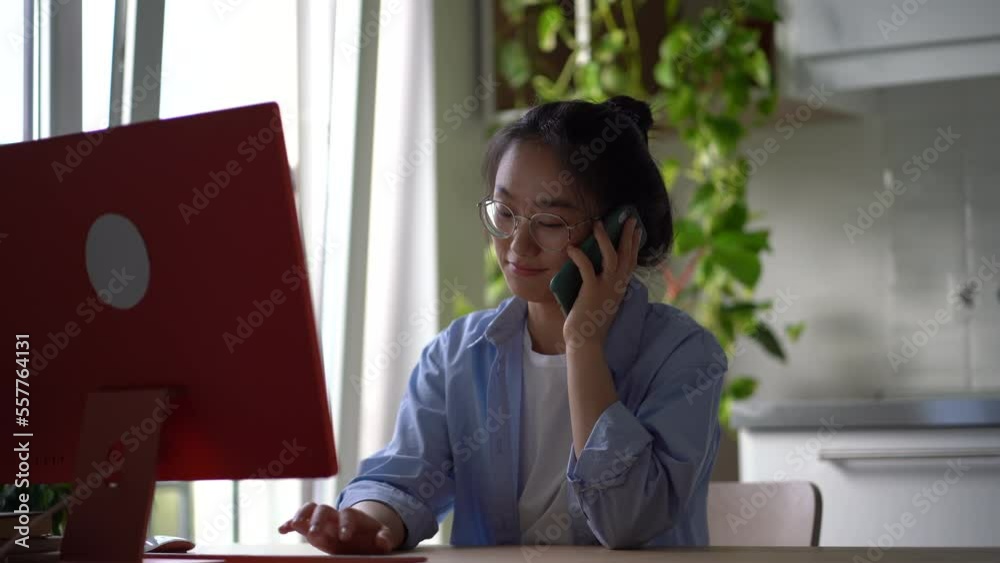 Korean girl remote employee having phone conversation while working on ...