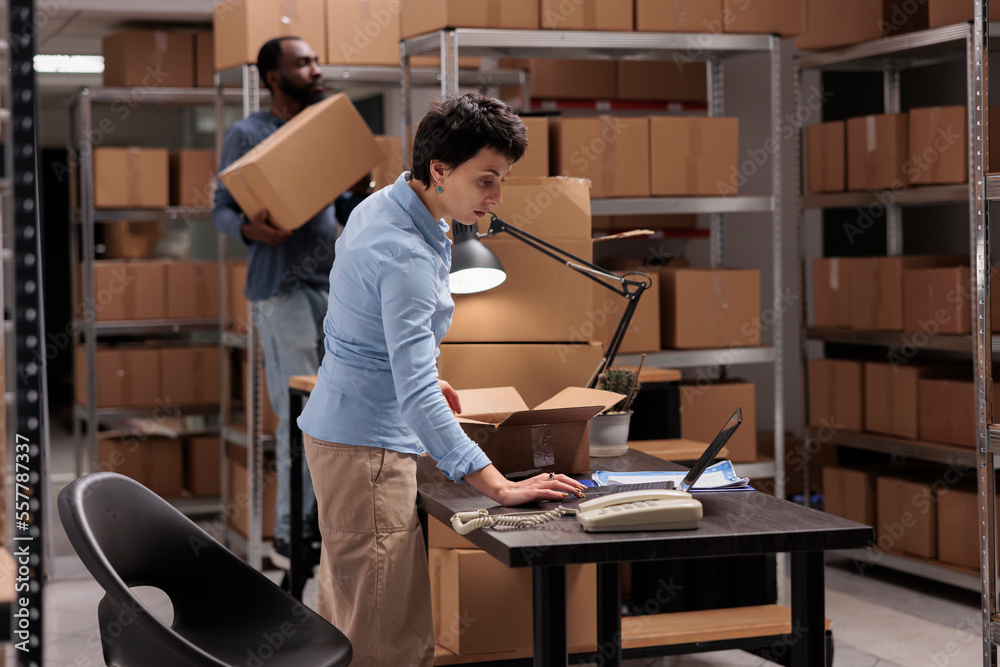Woman employee preparing clients orders putting trendy clothes in ...