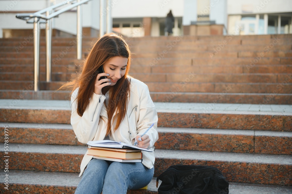 Female college student with books outdoors. Smiling school girl with ...