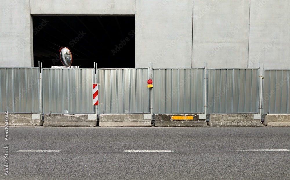 Concrete block barriers and metallic fence with red warning light in ...