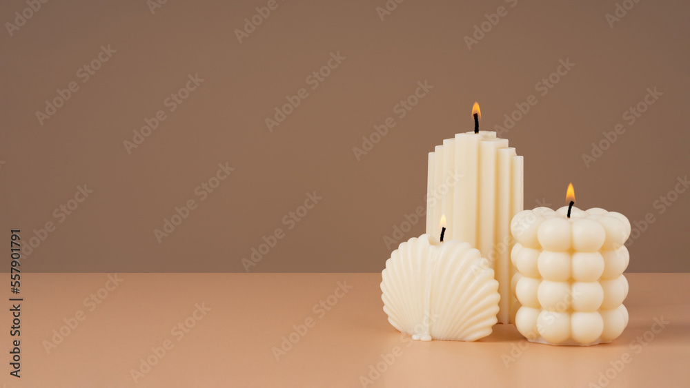Handmade olive wax different forms burning candle on a brown beige ...
