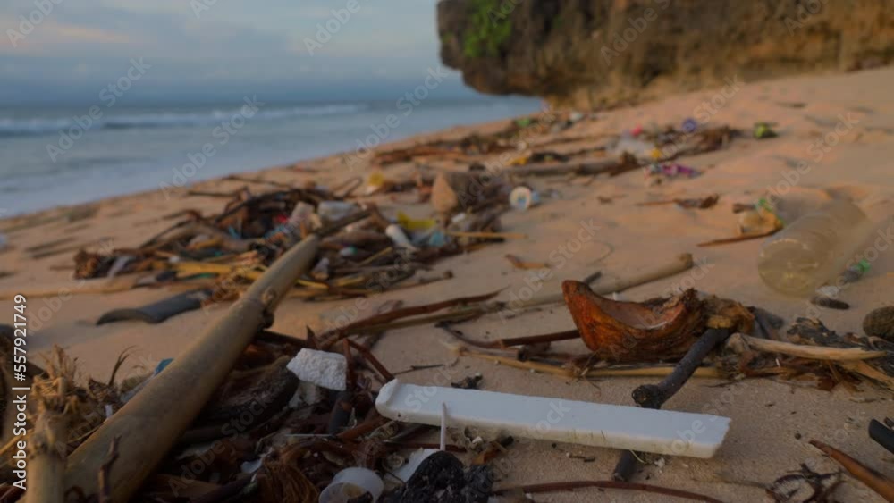 Close-up slow motion video of plastic trash on a wild sand beach in ...