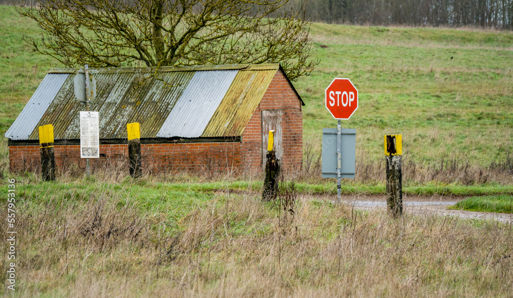 bright red Stop sign at a military tank crossing and road junction with ...