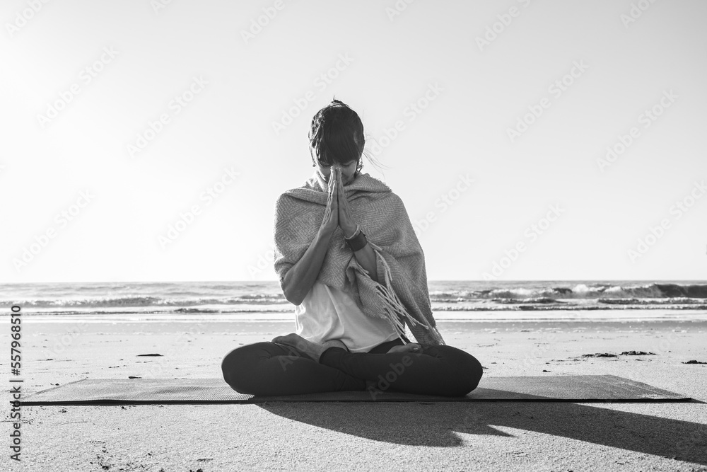 Portrait of a woman clasping hands while holding a japa mala at the ...