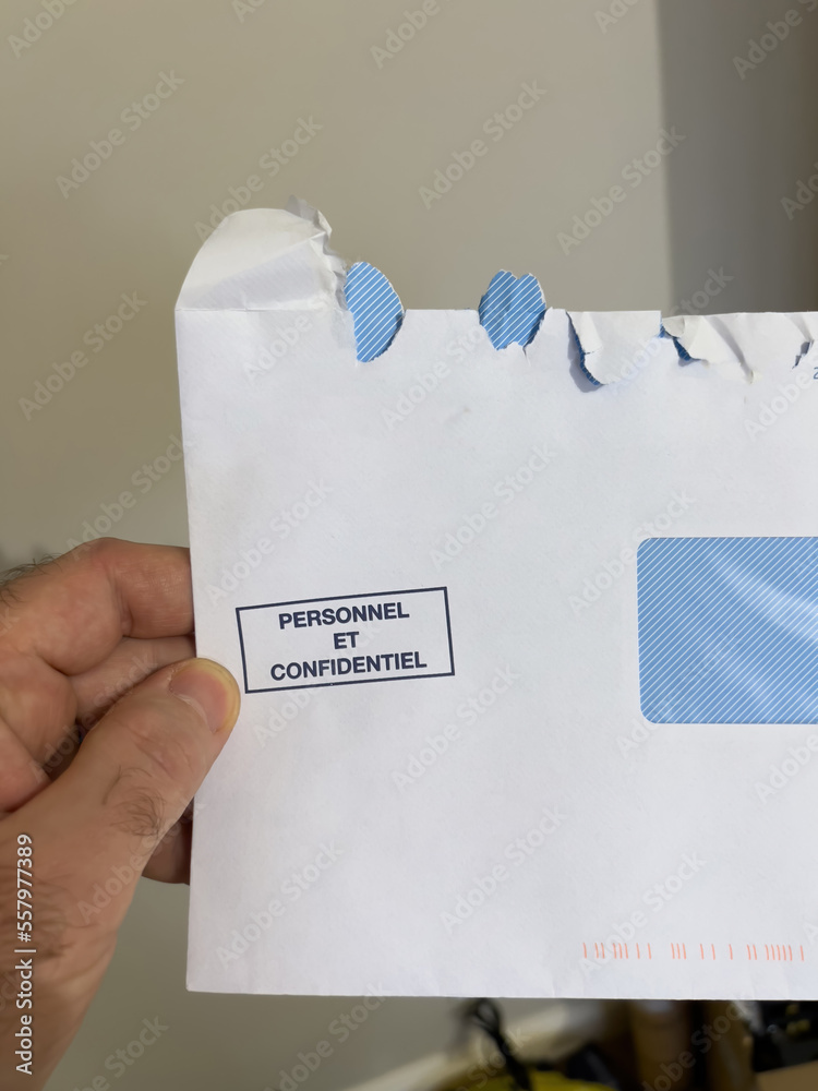 POV male hand holding open envelope with Personnel et confidentiel mark ...