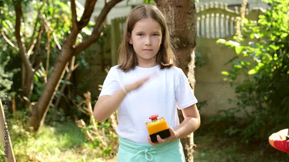 Girl, elementary school age child pressing a big red emergency stop ...