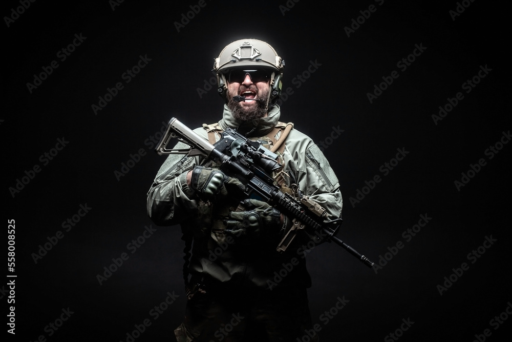 angry soldier in uniform with a rifle screaming at night, commando in ...