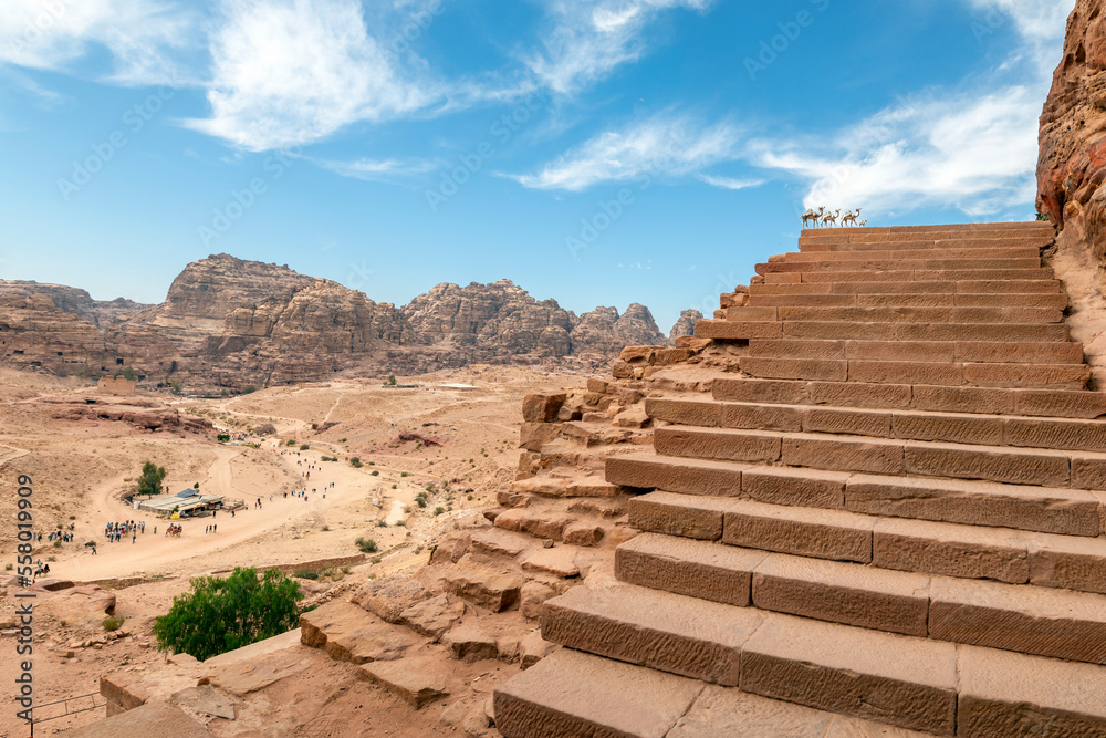 Miniature silver camels are posed atop a hill on ancient Nabatean steps ...