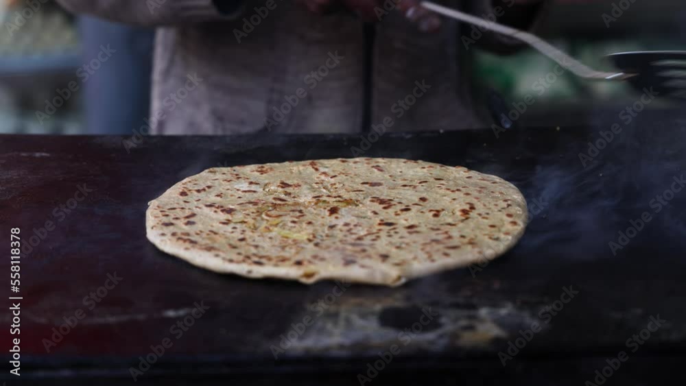 Making or cooking Aloo Paratha Indian potato stuffed flatbread with ...