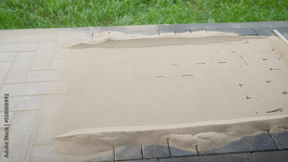 Sand with the help of the rule is rubbed into the seams of paving slabs ... Sand with the help of the rule is rubbed into the seams of paving slabs ...