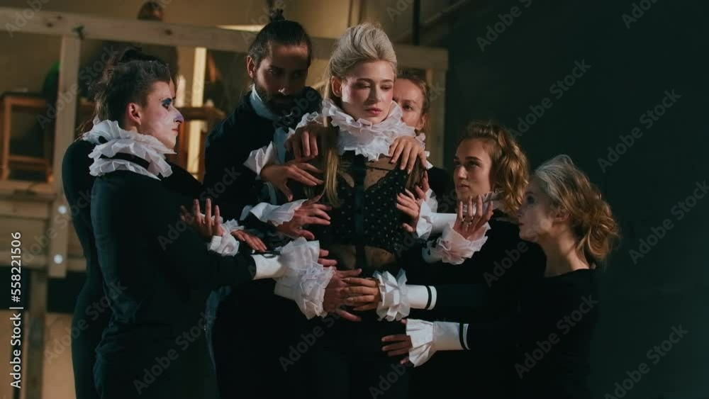 Group of actors touching body of sad woman in stage costume rehearsing ...