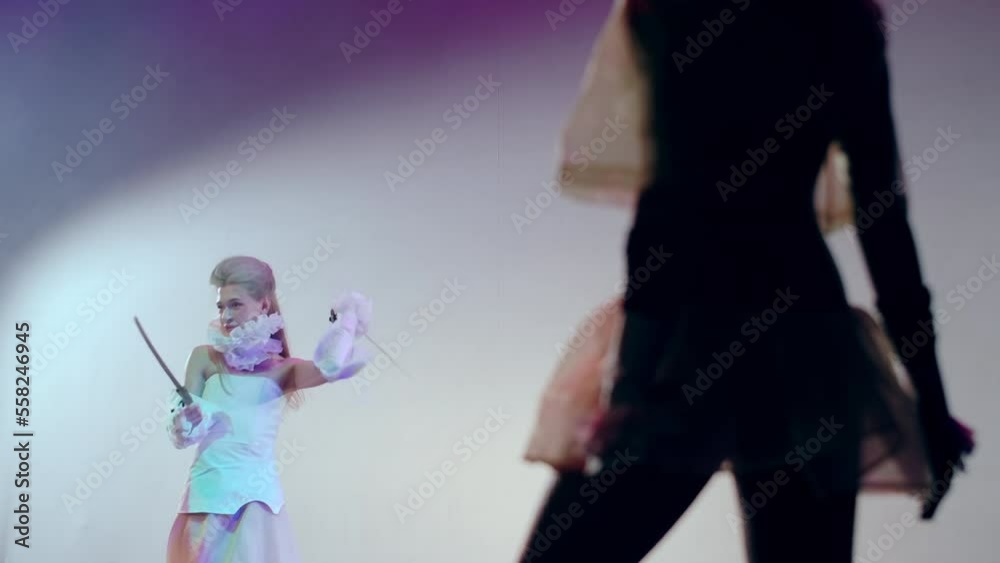 Slim beautiful woman in white dress with neck ruff fencing with swords ...