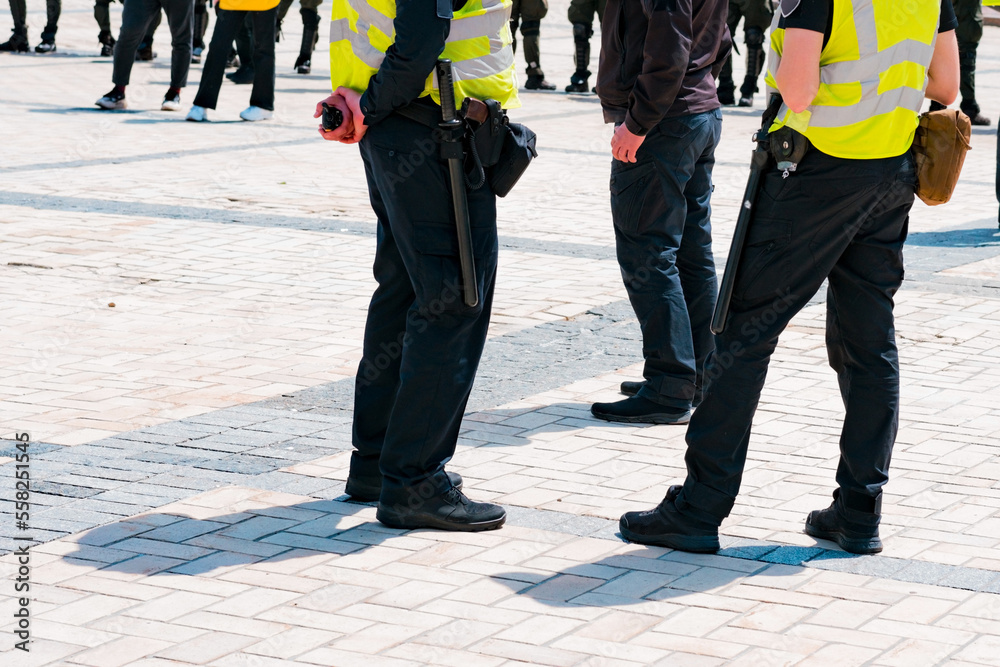 Police officers with rubber batons stand on the street and control the ...