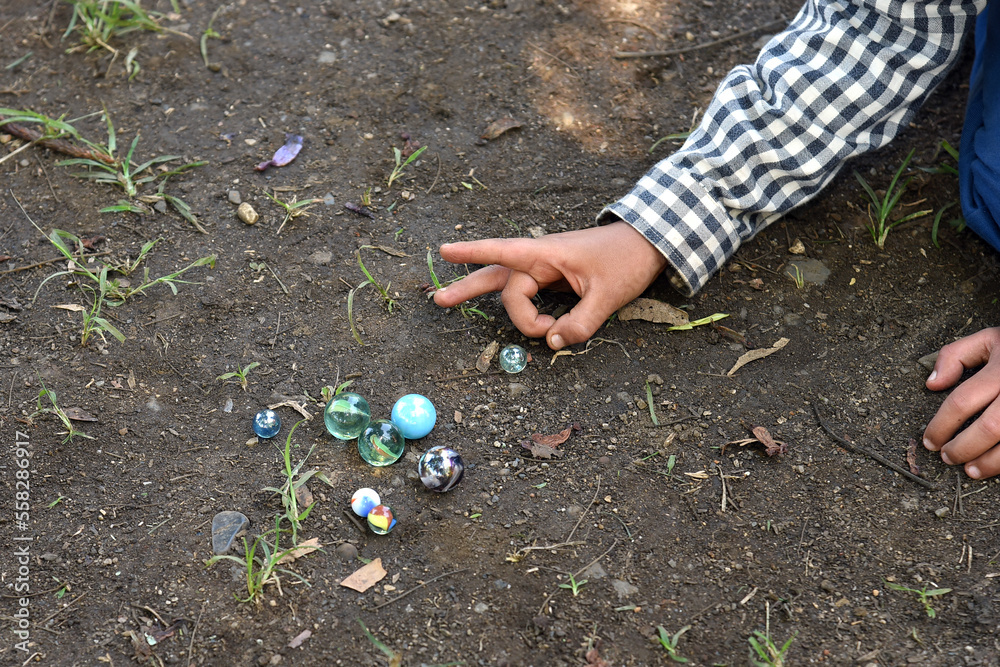 Boy playing with marbles on the sidewalk. retro game, having fun with ...
