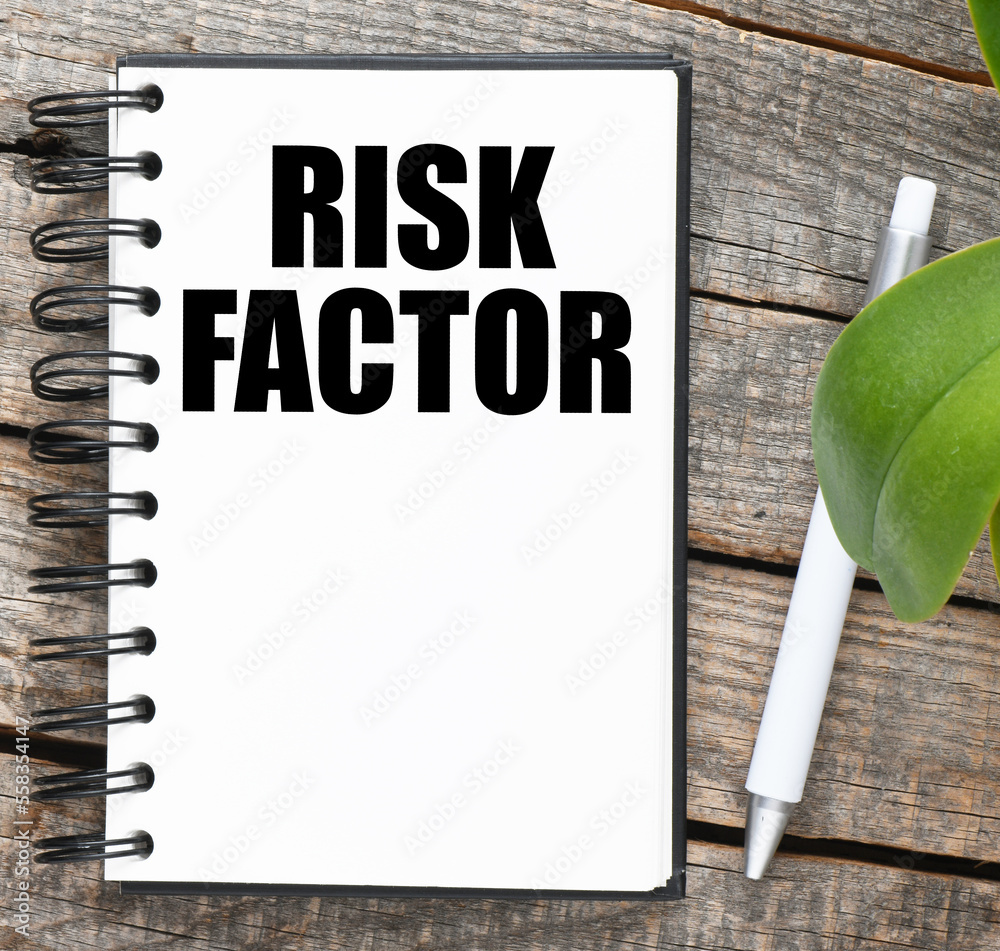 RISK FACTOR words written in an office notebook. Stock Photo | Adobe Stock
