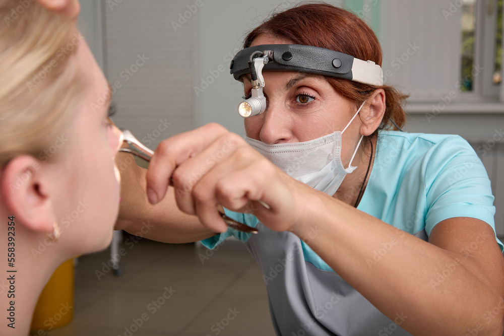 Fotka „An otolaryngologist with help of a nasal mirror examines the ...