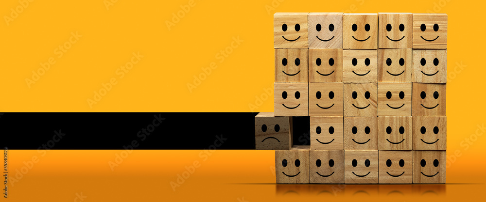 Large group of happy smiley faces and a sad one. Group of wooden blocks ...