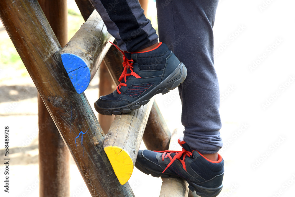 Boy climbing up a wooden log in the park. motor skills concept. Child ...