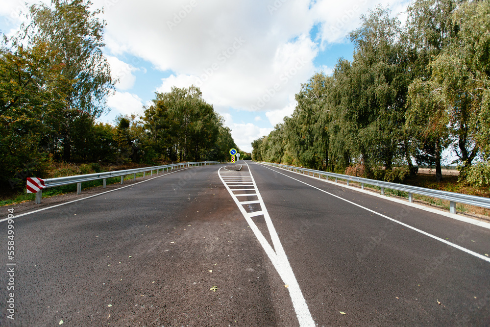 New asphalt road with markings and road signs in the sun's rays Stock ...