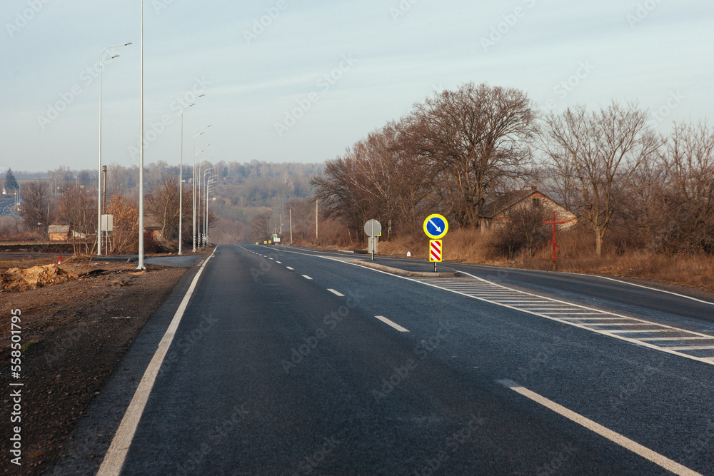 New asphalt road with markings and road signs in the sun's rays Stock ...
