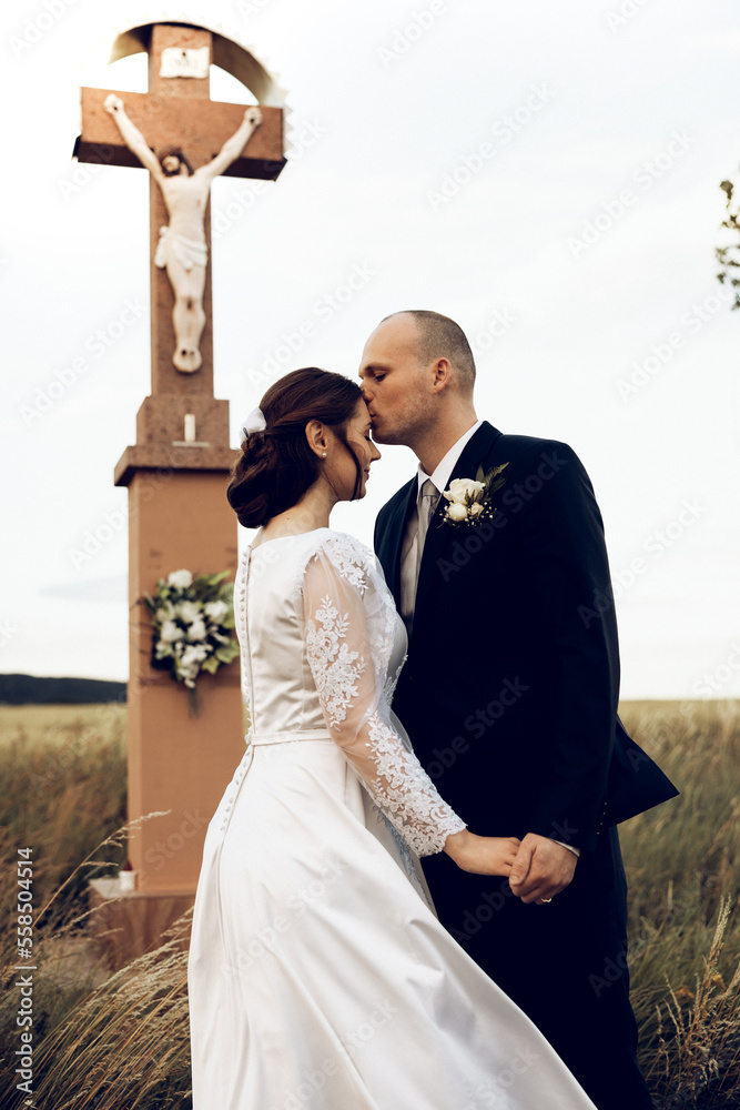 bride and groom holding hands in front of jesus christ statue during ...
