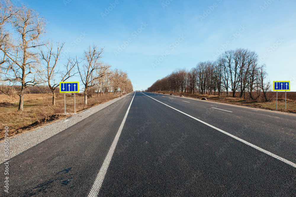 New asphalt road with markings and road signs in the sun's rays Stock ...
