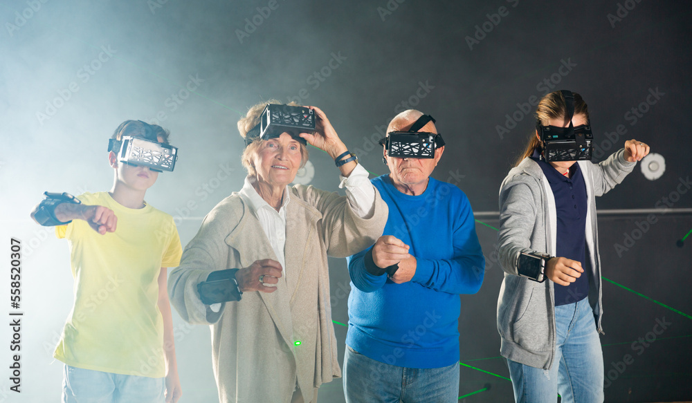 Family of four people, grandparents and grandchildren, playing VR games ...