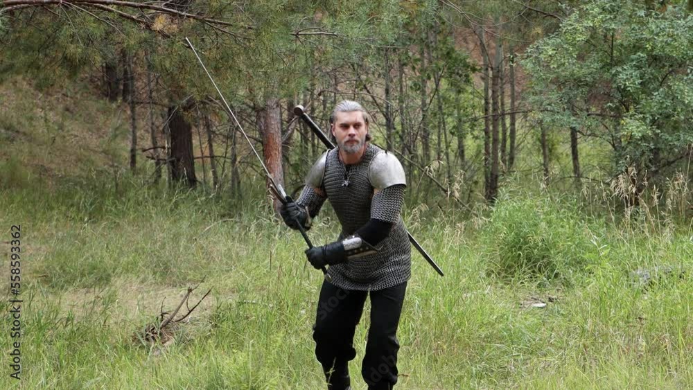 A medieval warrior with gray hair, dressed in chain mail with shoulder ...