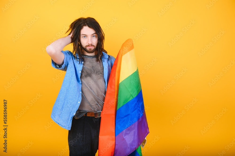 Handsome young man with pride movement LGBT Rainbow flag on shoulder ...