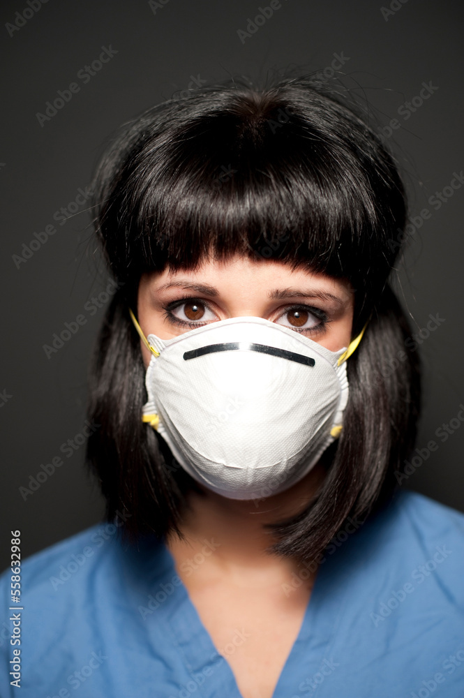 Studio portrait of 25 year old caucasian female wearing a N95 mask ...