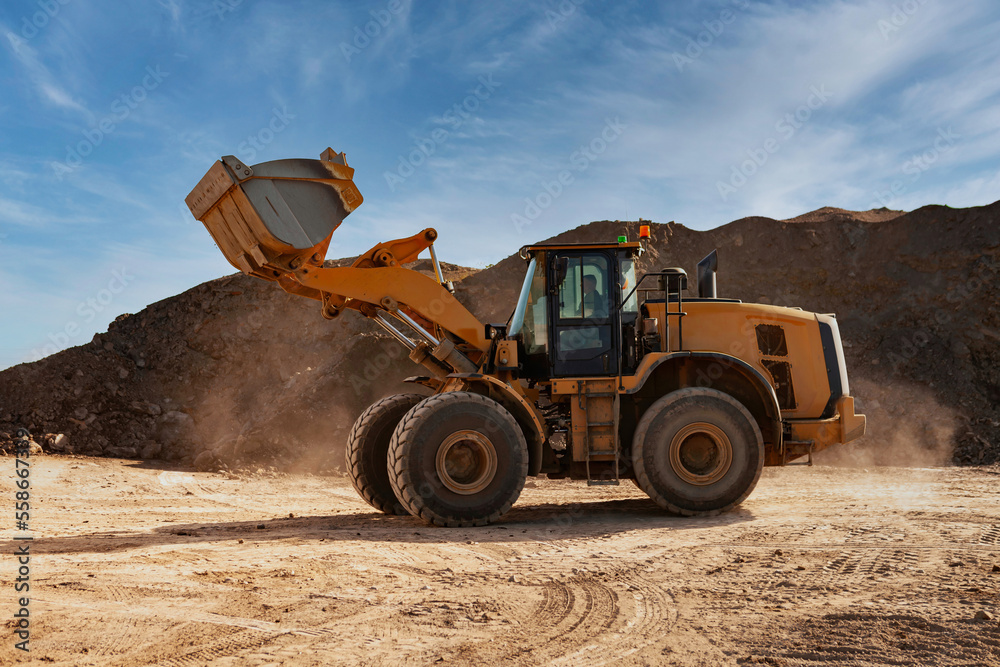 Wheeled loading shovel tractor moving rocks in a quarry Stock Photo ...