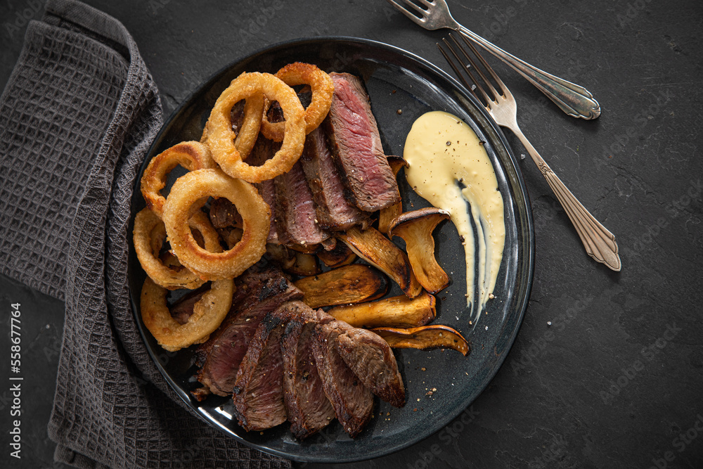 Entrecote Steak vom Rind medium rare gebraten mit Zwiebelringe, Pommes ...