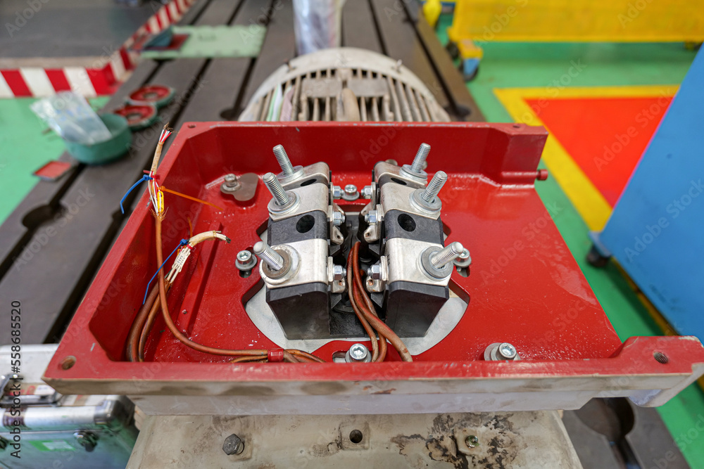 An induction motor's terminal block showing the wires connected to the ...