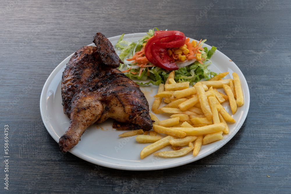 Medio pollo a la parrilla con papas fritas Stock Photo | Adobe Stock