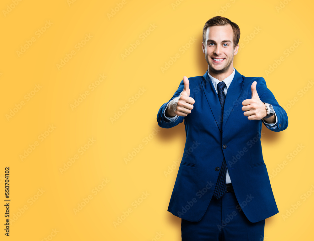 Cheerful smiling businessman in blue confident suit showing two thumbs ...
