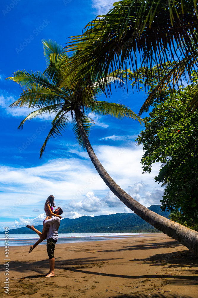 A romantic couple in love on a tropical beach in Costa Rica; a man ...