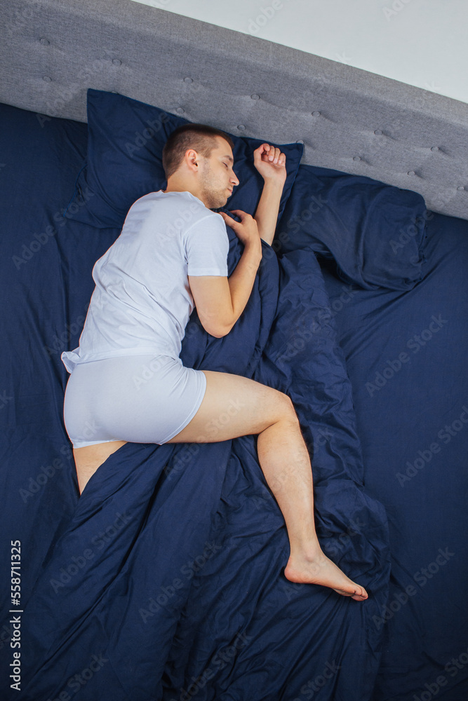 Top view of a handsome young man sleeping comfortably on the bed at ...