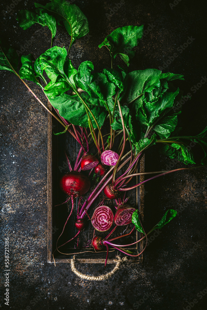Beetroots, some sliced showing interior, with leaves attached, in ...