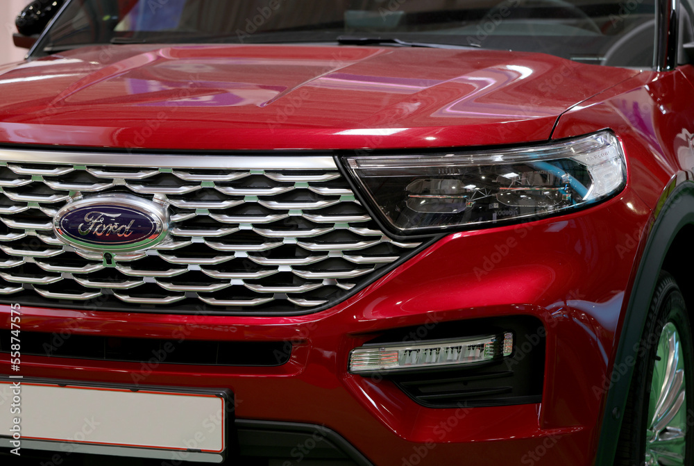Front-side view with logo and head light detail of a new red SUV Ford ...