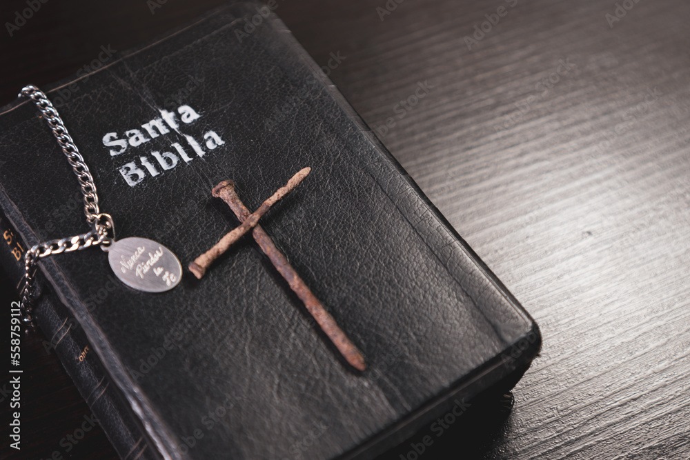 Portada de santa biblia en una meza y clavos oxidados formando una cruz ...
