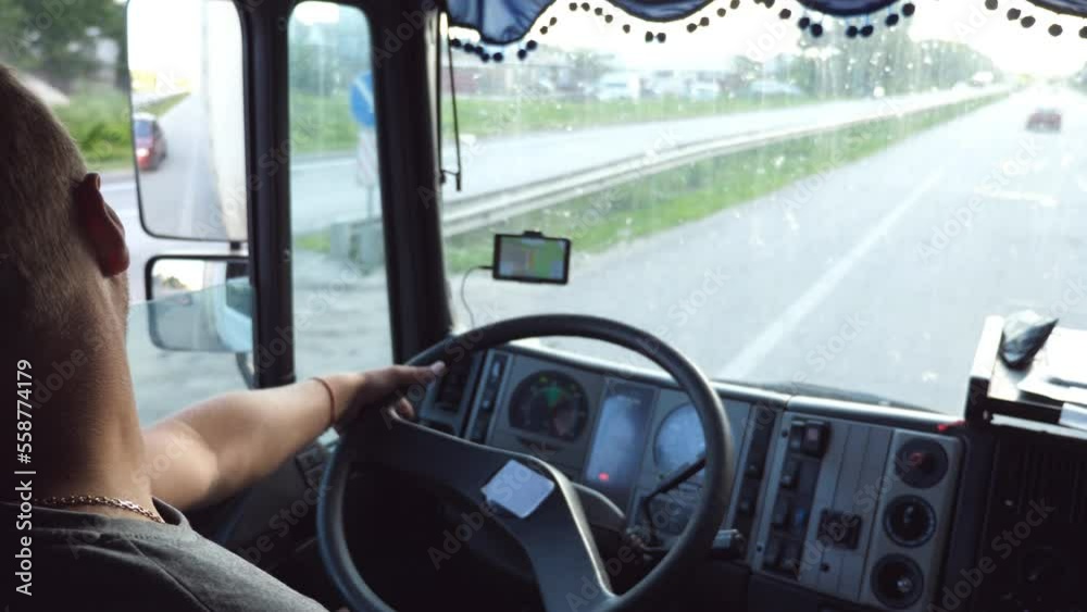 Driver holds hand on the steering wheel and driving lorry. Trucker ...