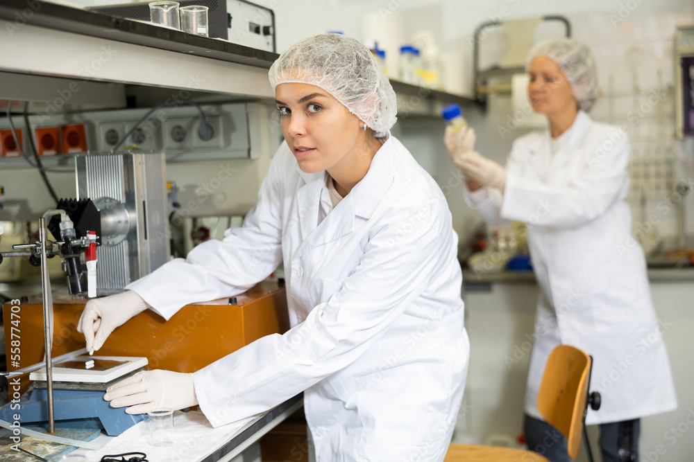 Young woman pharmacist makes weight measurement of medicines in ...