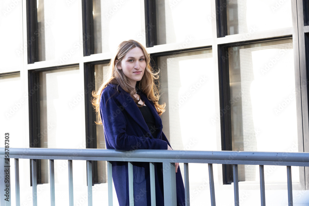 Trans woman posing next to a railing. Stock Photo | Adobe Stock