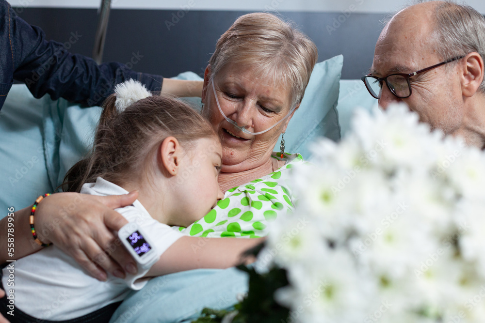 Little girl waving goodbye to sick grandmother. Elderly woman lying in ...