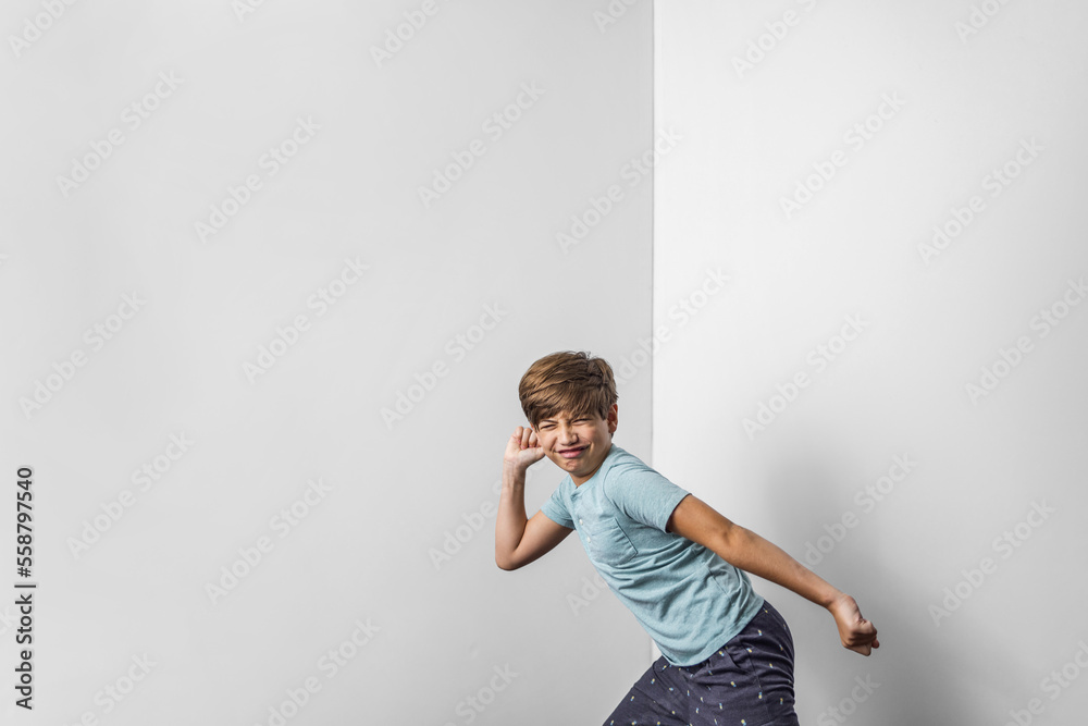 A pre-teen tween boy making a funny scrunched up face looking like he ...