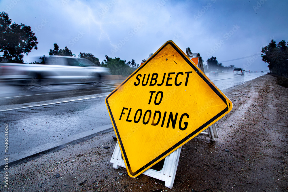 Road Sign stating Subject to Flooding with rainy highway in the ...