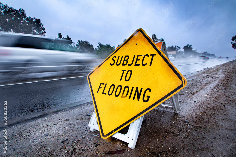 Road Sign stating Subject to Flooding with rainy highway in the ...