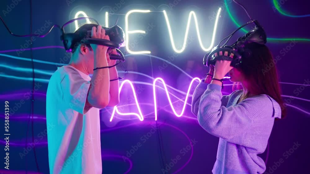 Cyber gamer in VR glasses plays virtual reality game in neon futuristic ...
